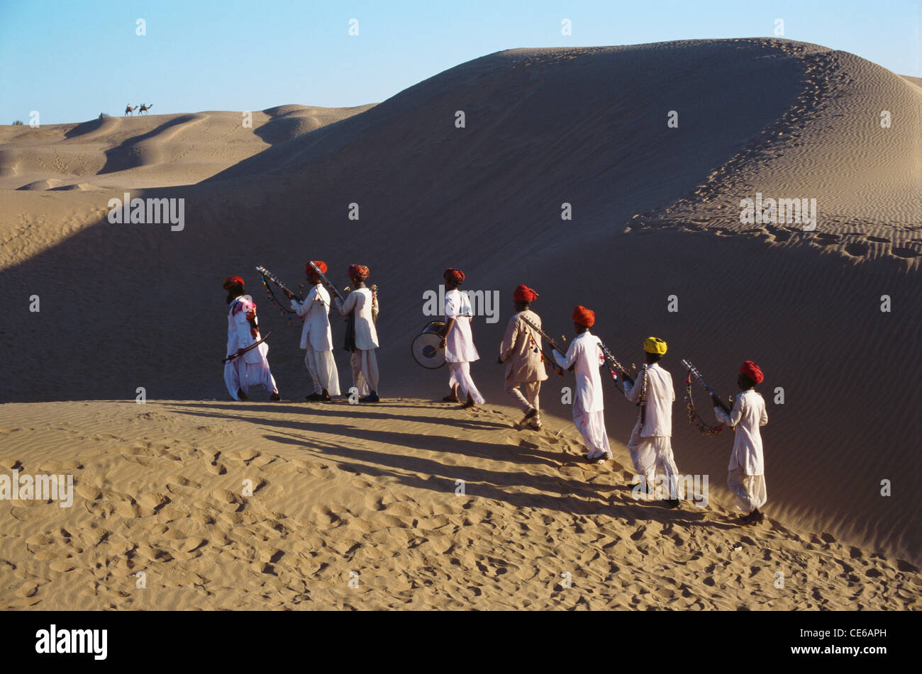 Indian Rajasthani musicians walking on Sam desert sand dunes ...