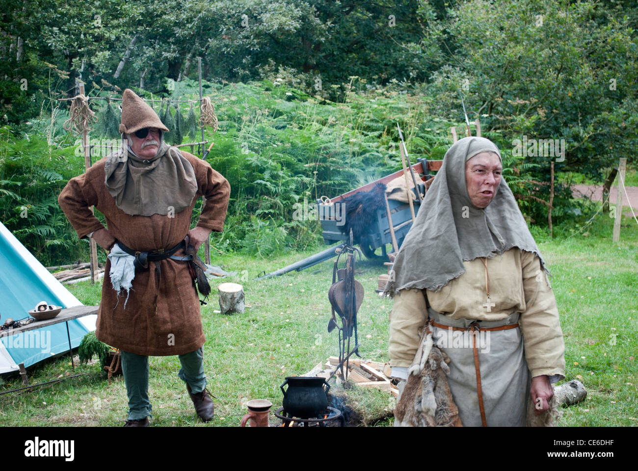 A man and a woman dressed as peasants in medieval costume at campsite ...