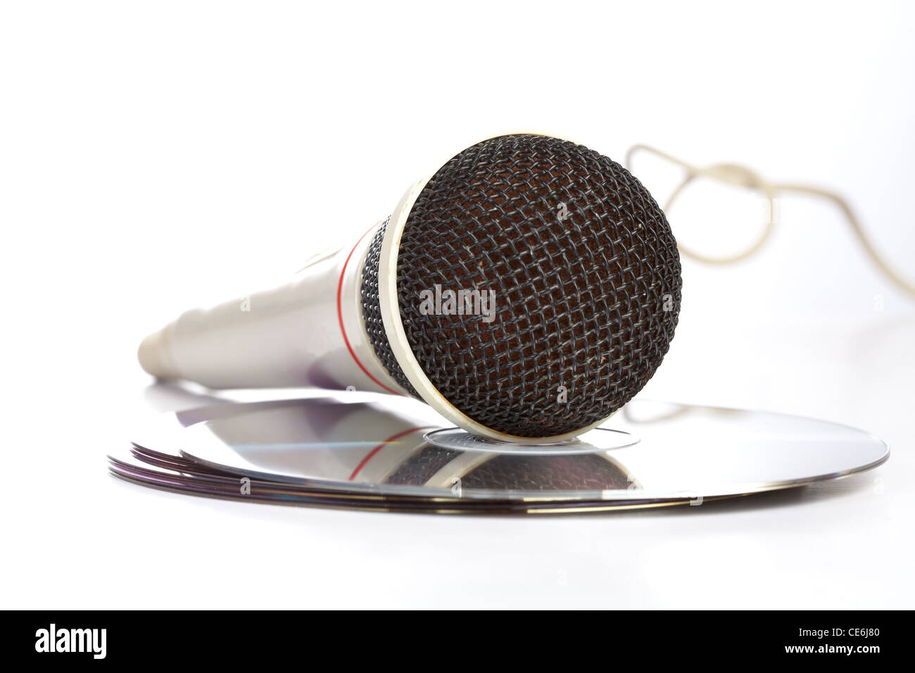 The microphone lays on compact discs on white background Stock Photo ...