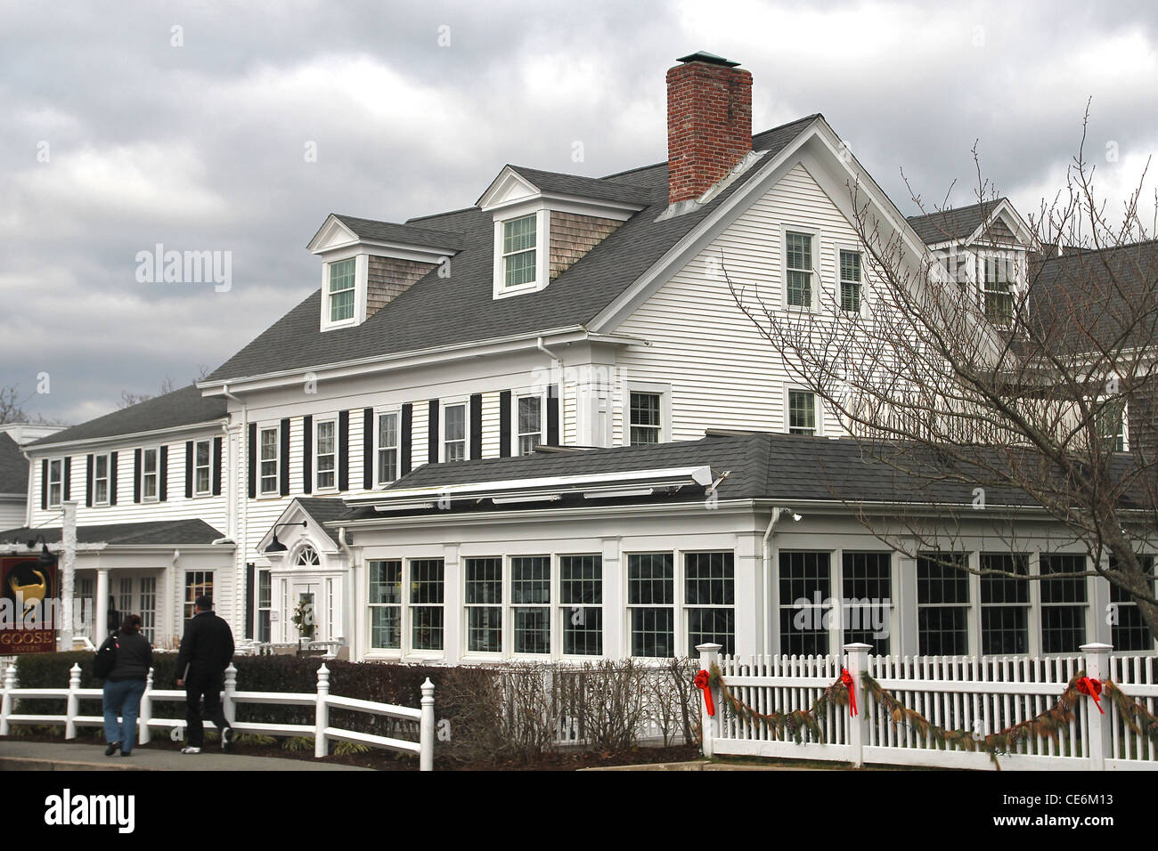 People walk past the Wild Goose Tavern at the Wayside Inn in winter ...