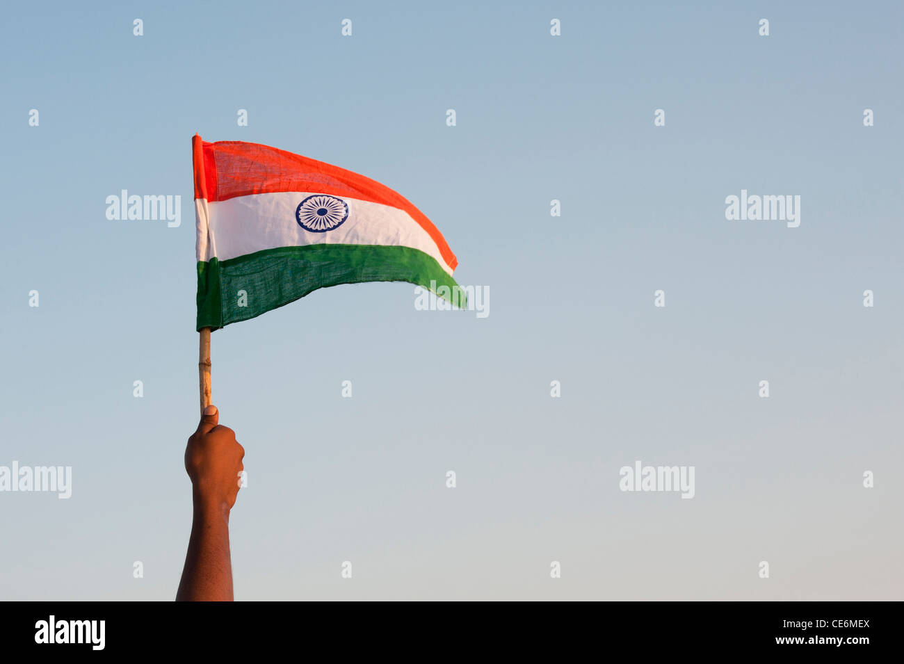 Indian mans hands holding an Indian flag against a blue sky. India ...
