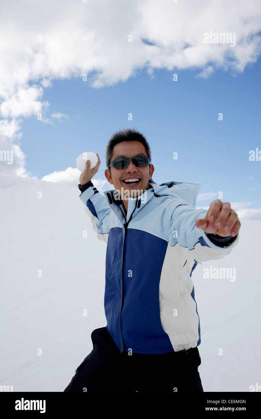 man throwing snowball and smiling Stock Photo - Alamy