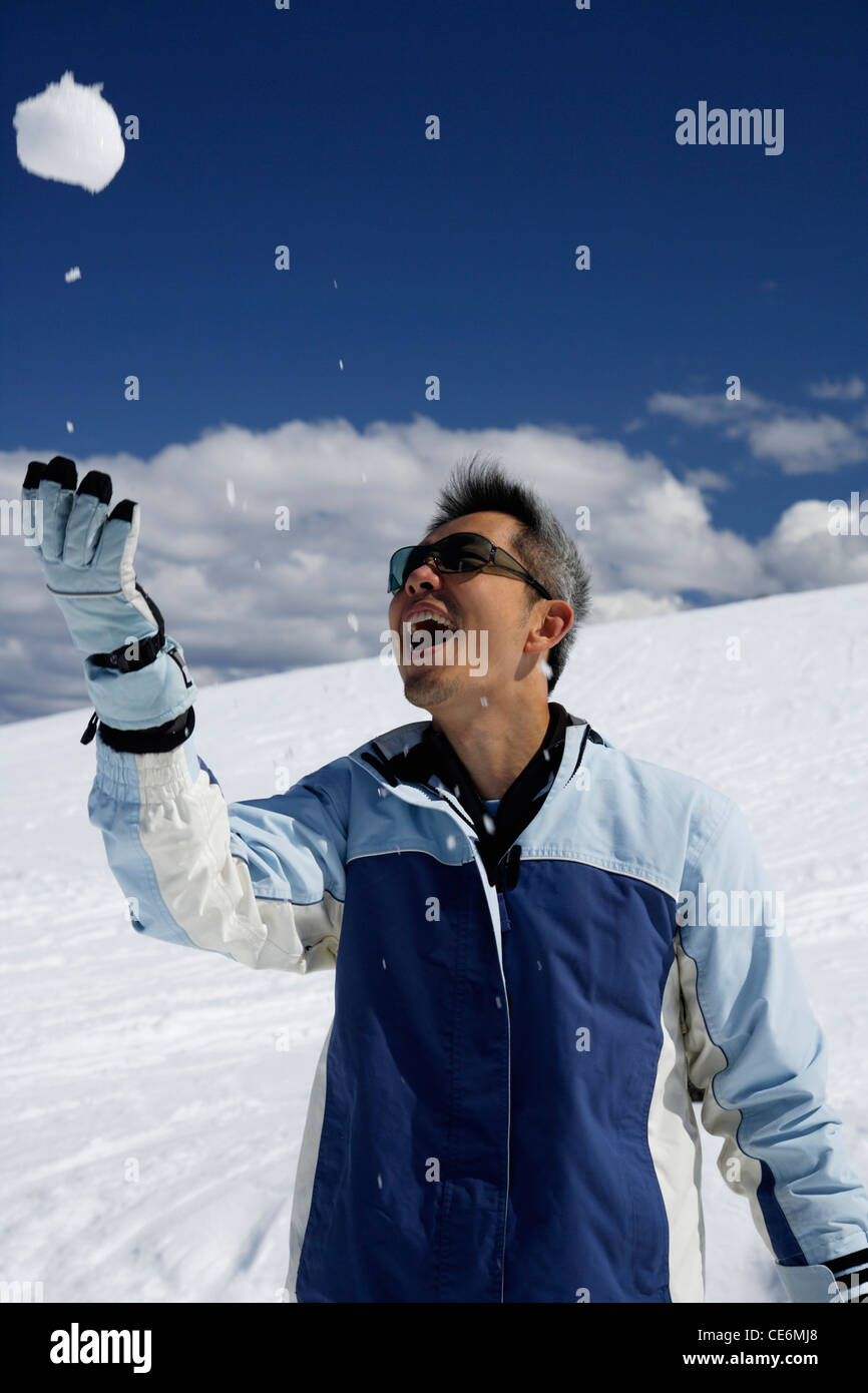 man throwing snow ball into air and smiling Stock Photo - Alamy