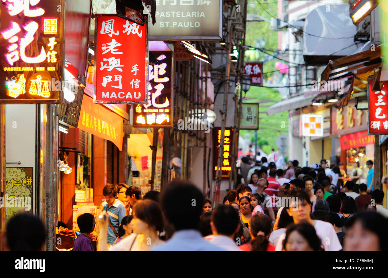Street signs with busy crowd underneath Stock Photo - Alamy