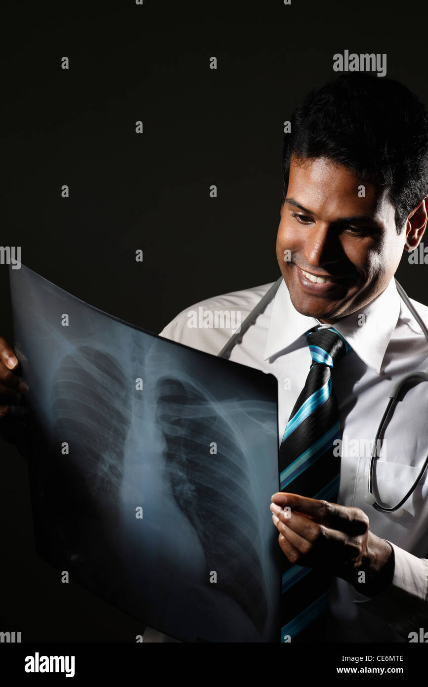 Doctor looking at X ray smiling Stock Photo - Alamy