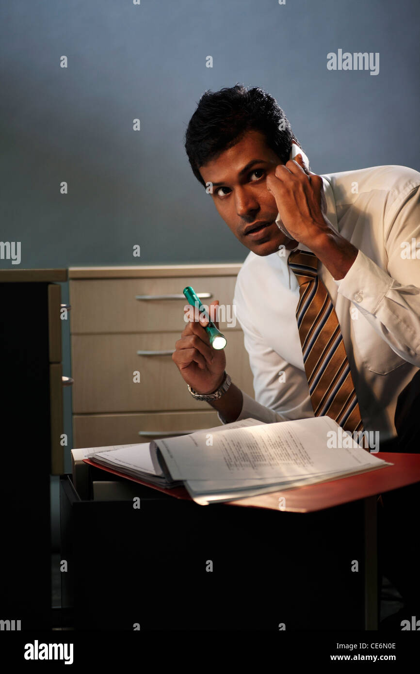 Business man looking at documents with a flashlight at night Stock ...
