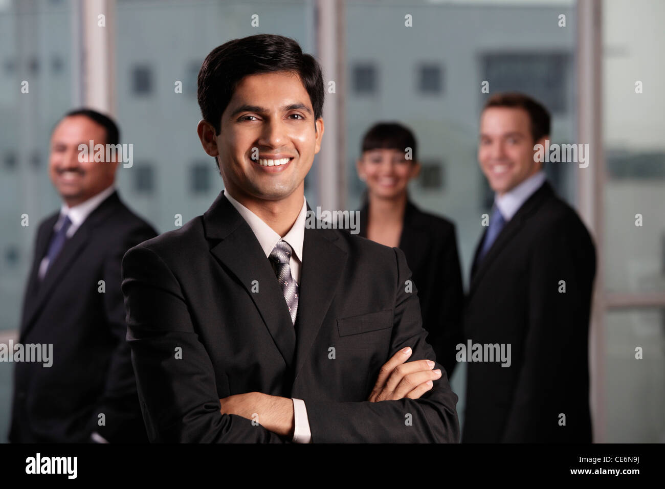 Indian man smiling in front of his colleagues Stock Photo - Alamy