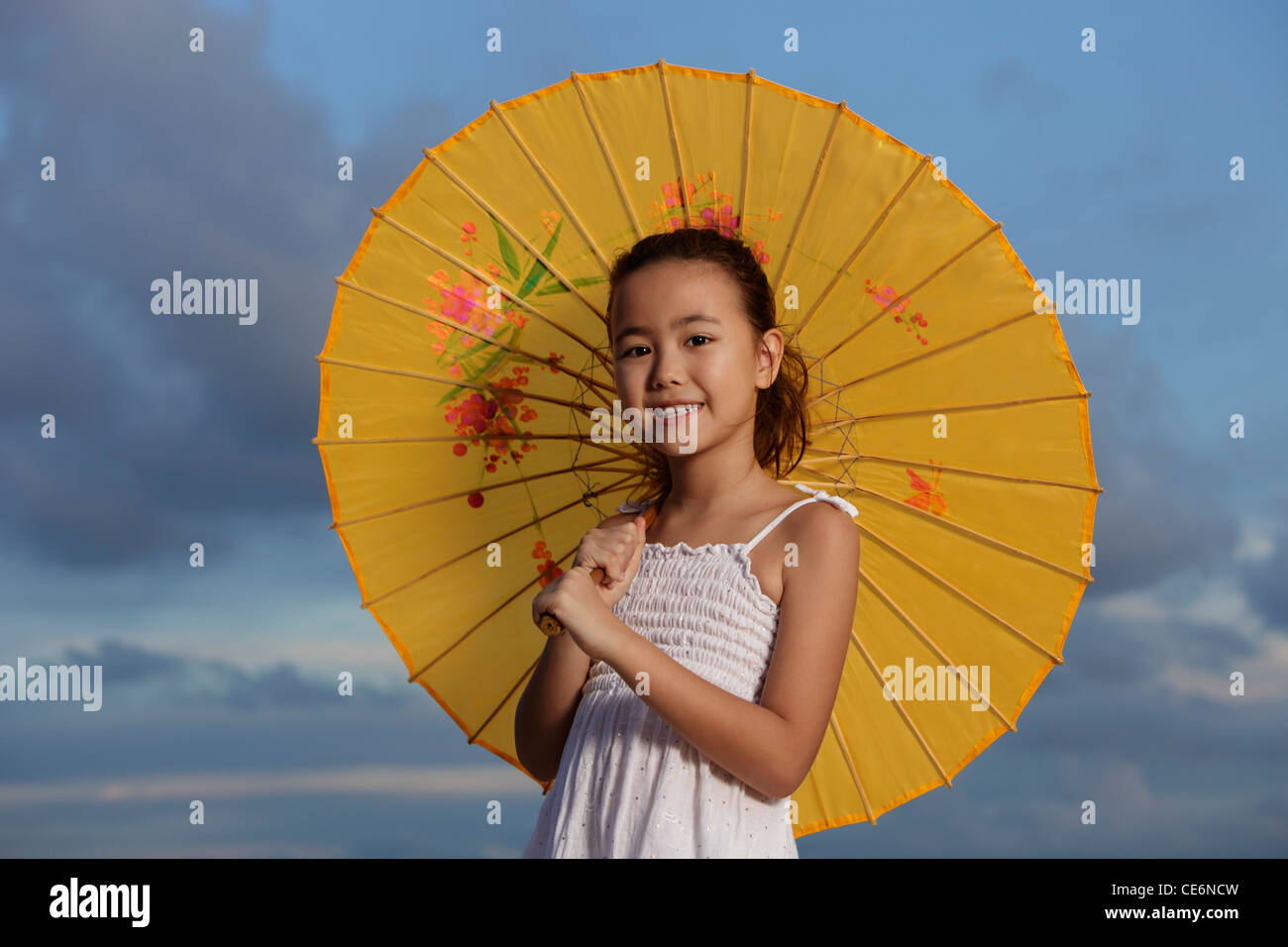 young girl holding yellow Chinese umbrella and smiling Stock Photo - Alamy