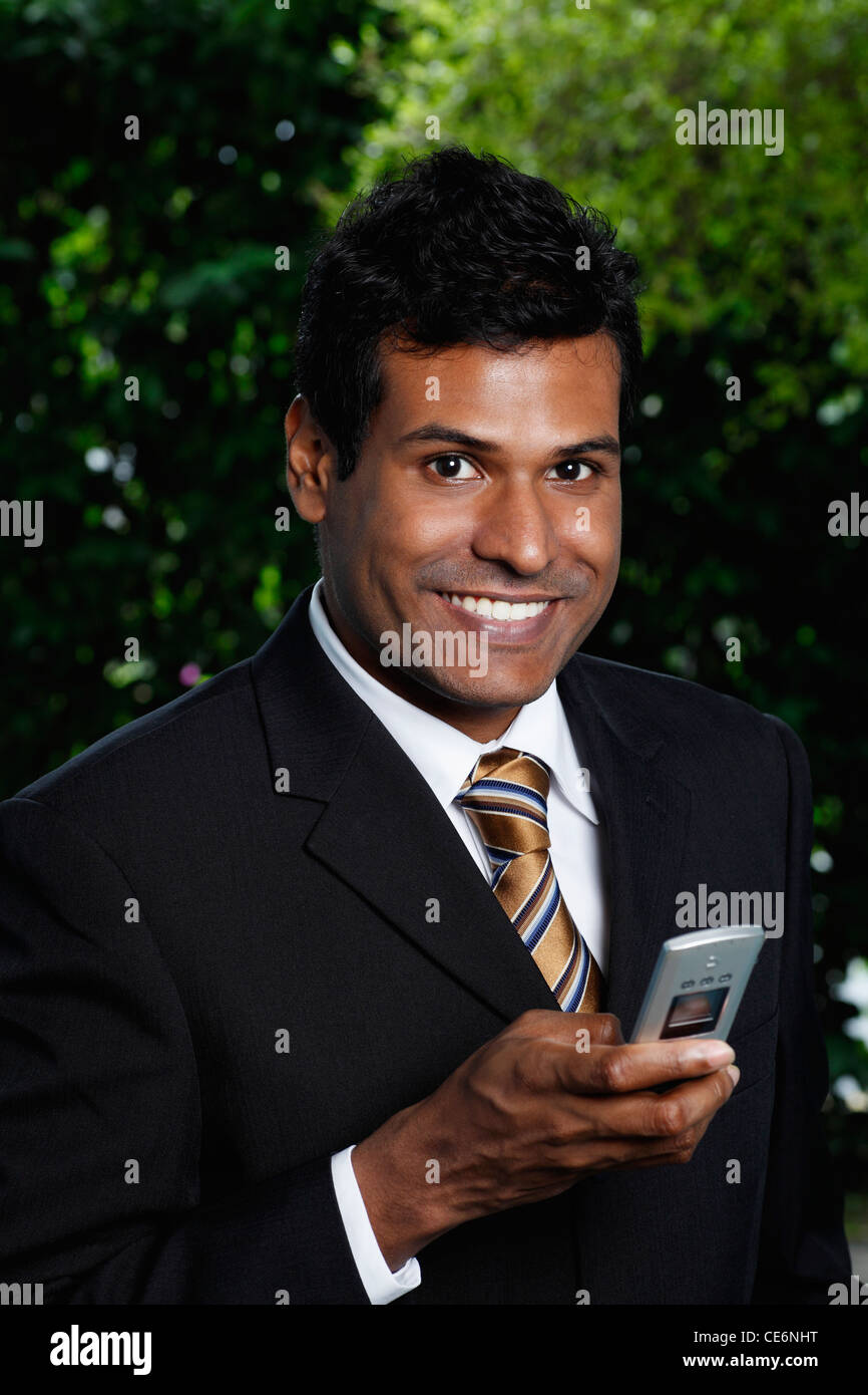 Indian man smiling holding phone Stock Photo - Alamy