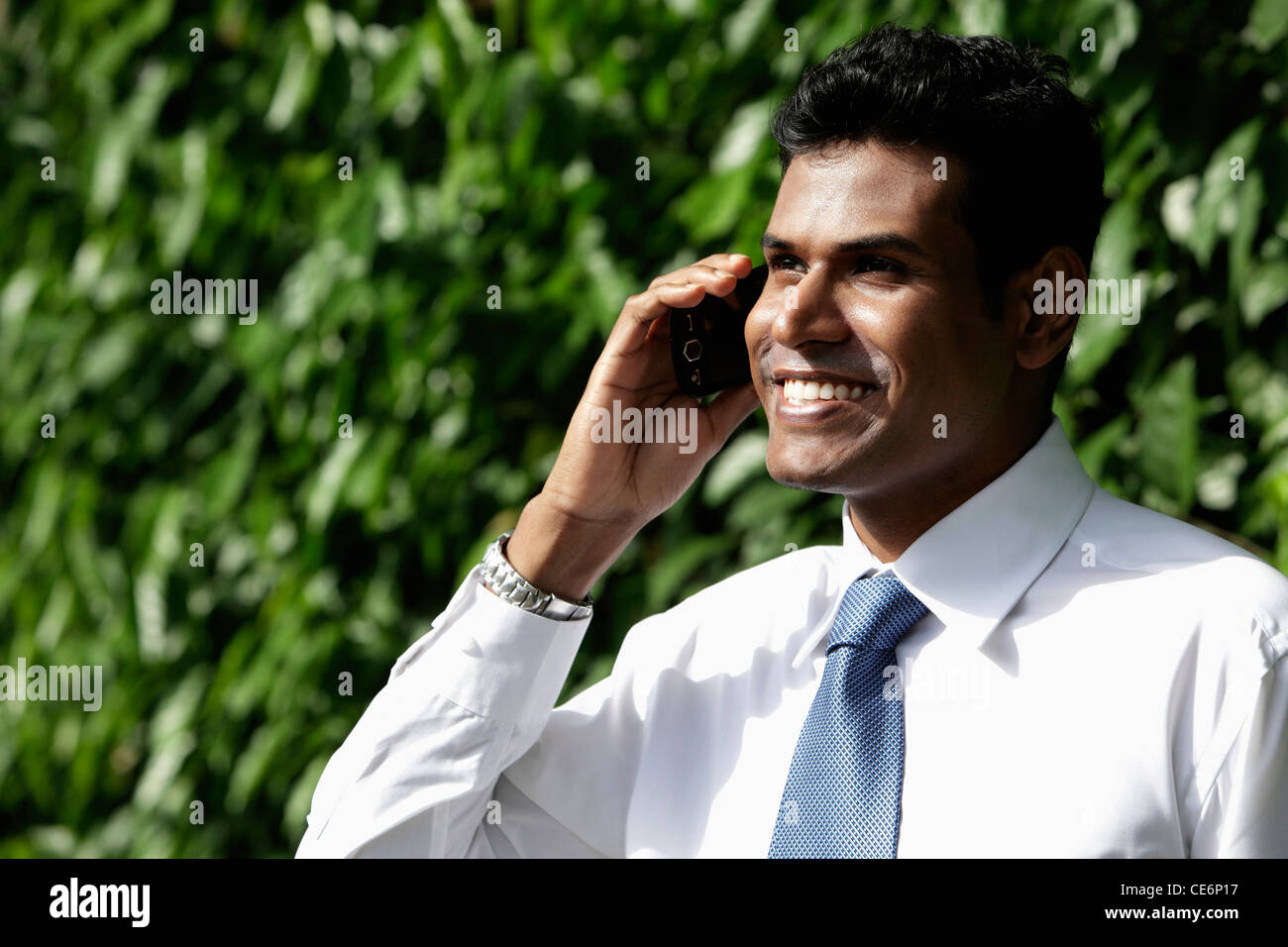 Cropped shot of Indian man talking on phone and smiling Stock Photo - Alamy