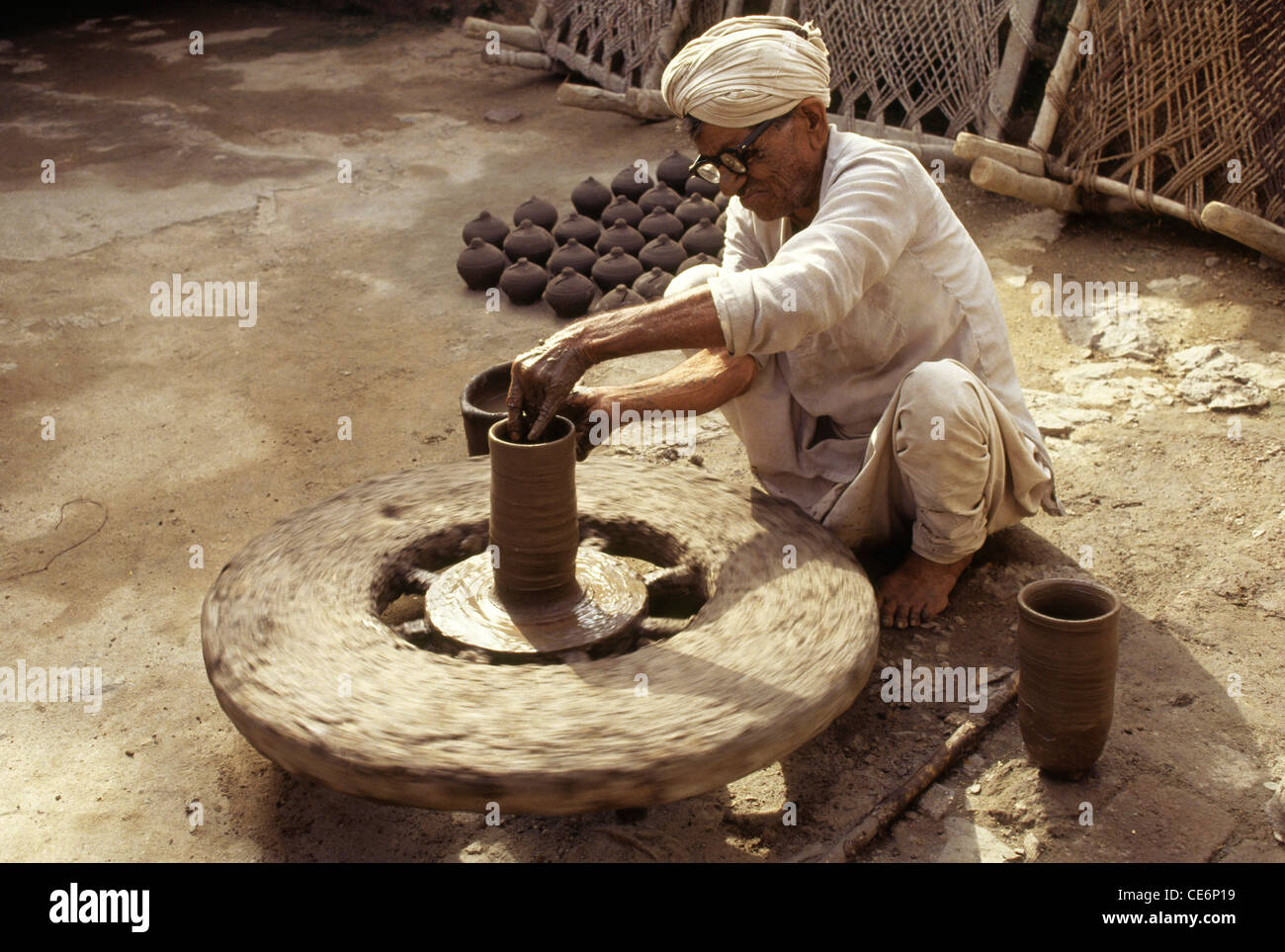 Pottery ; potter giving shape to clay pot on wheel rajasthan india ...