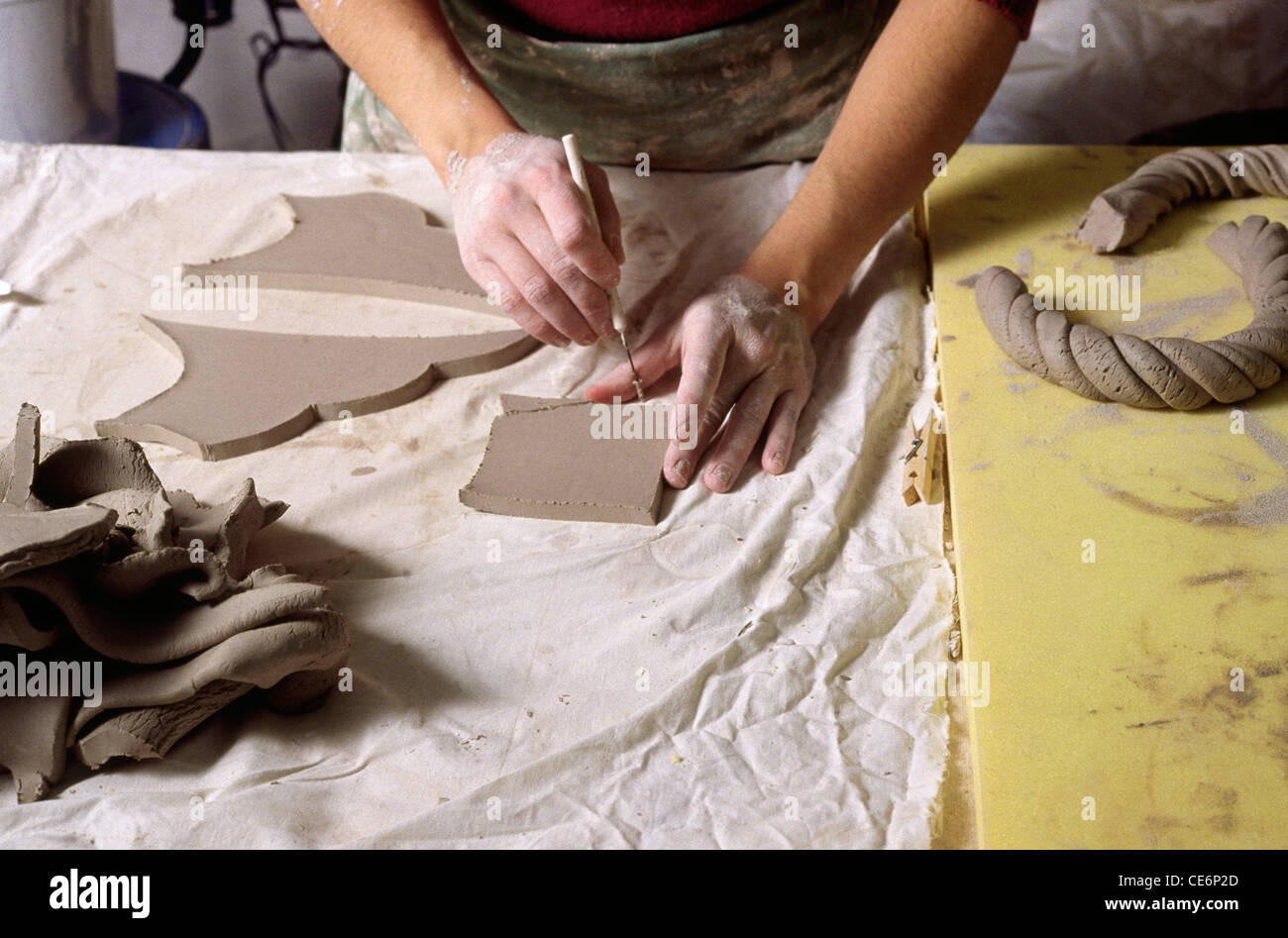 Artist hand cutting clay Stock Photo - Alamy