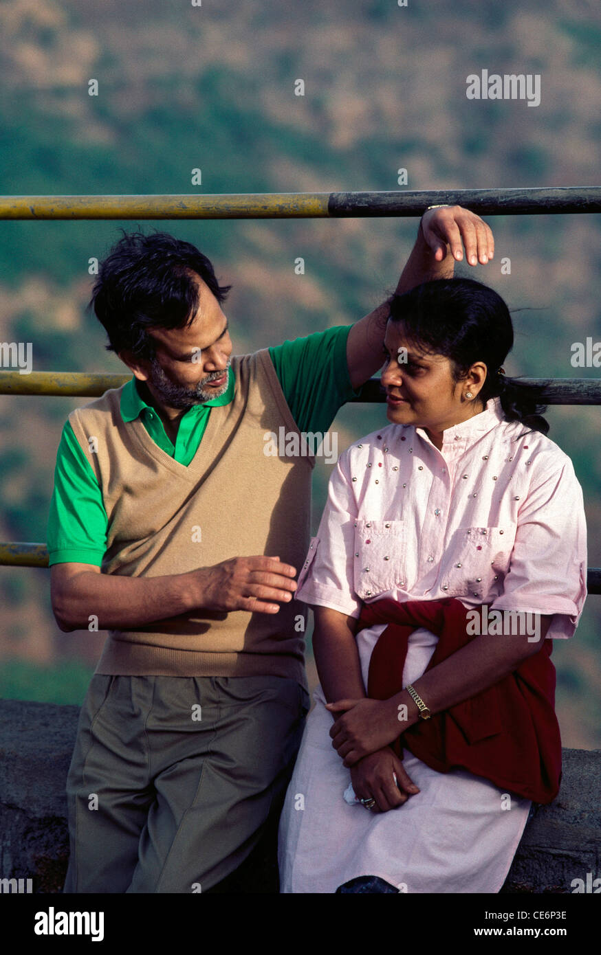 Couple man and woman enjoying leaning against railing Stock Photo - Alamy
