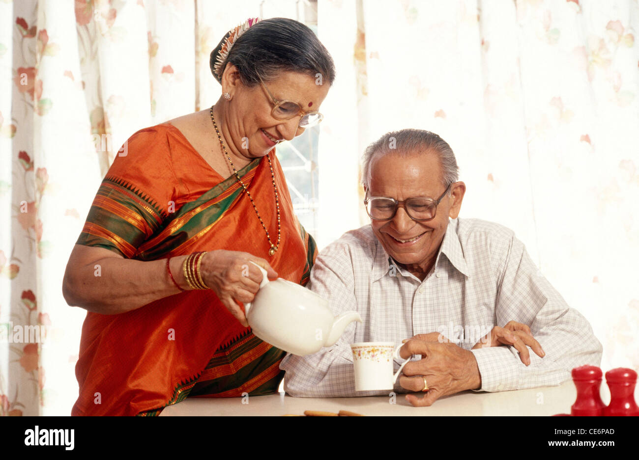 Old woman pouring tea in cup of old man MR#318&319 Stock Photo - Alamy