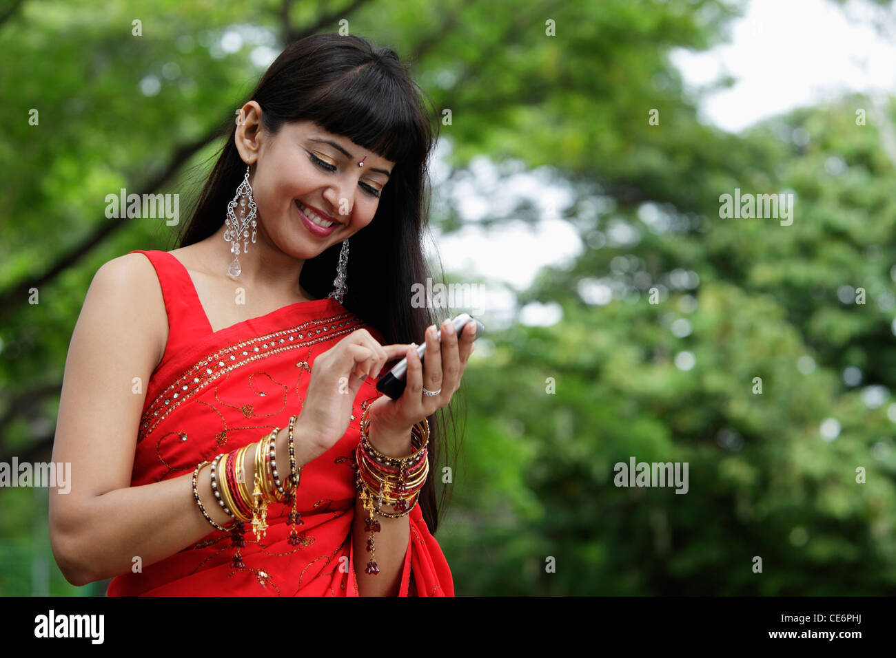 Indian woman texting on phone, outdoors Stock Photo - Alamy