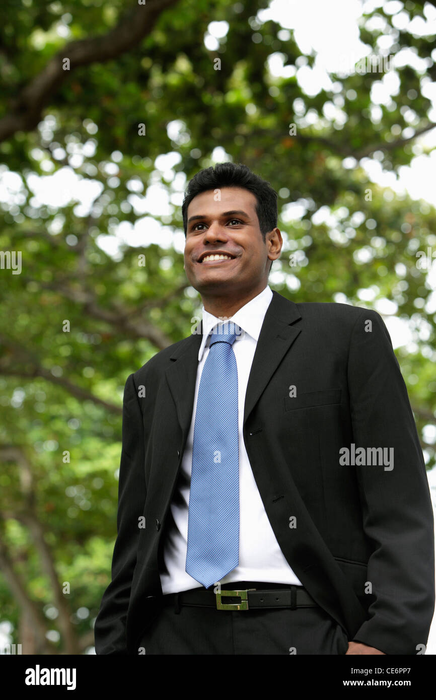 Indian man smiling outdoors with tree in background Stock Photo - Alamy