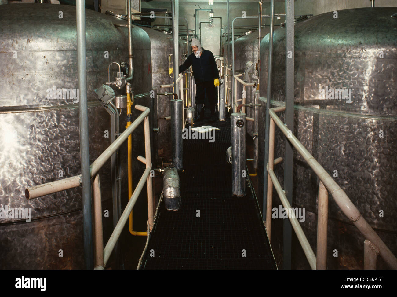 Indian man worker working with storage tanks in factory ; india ; asia ...