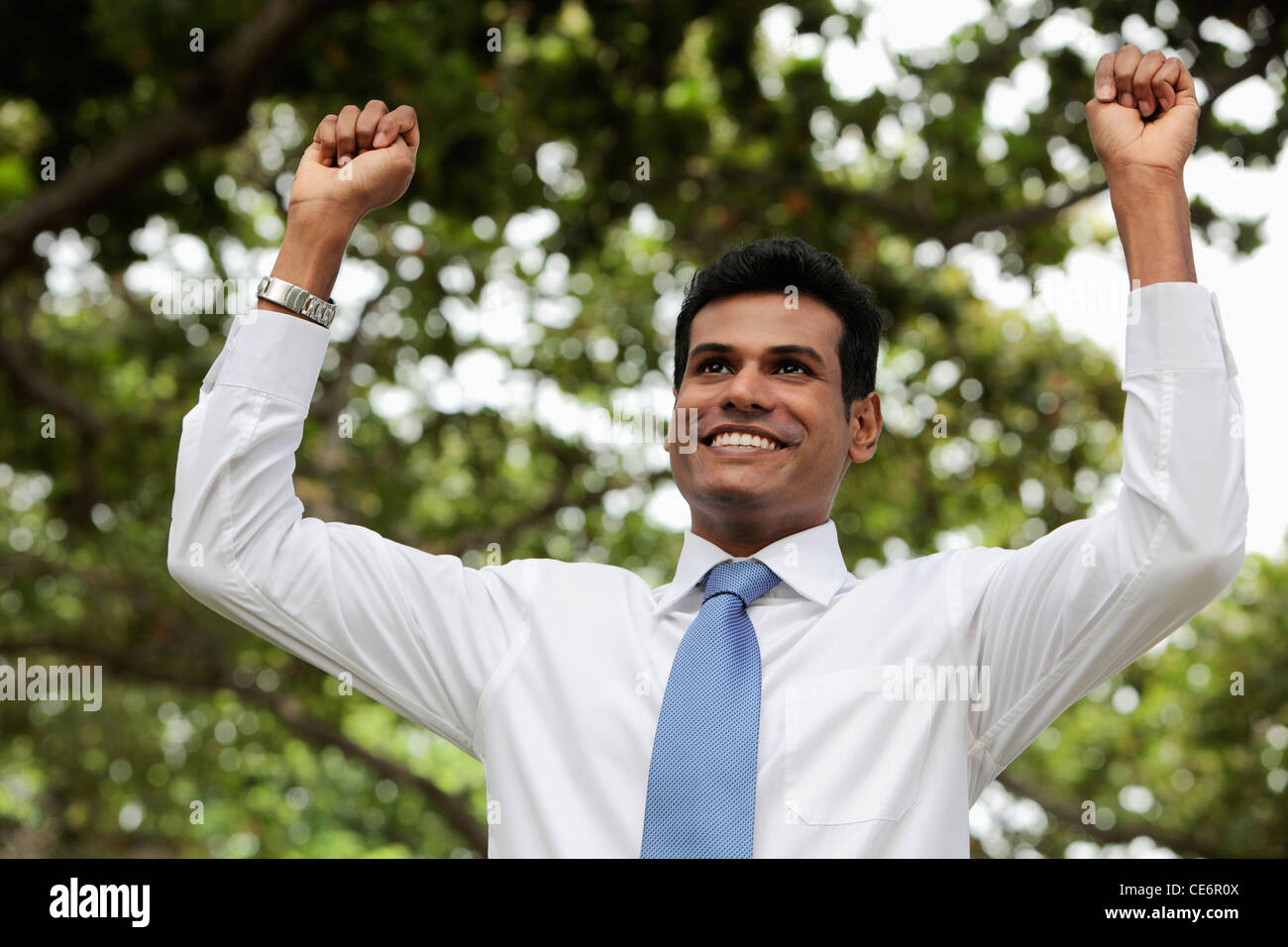 Indian man with his arms raised smiling outdoors Stock Photo - Alamy