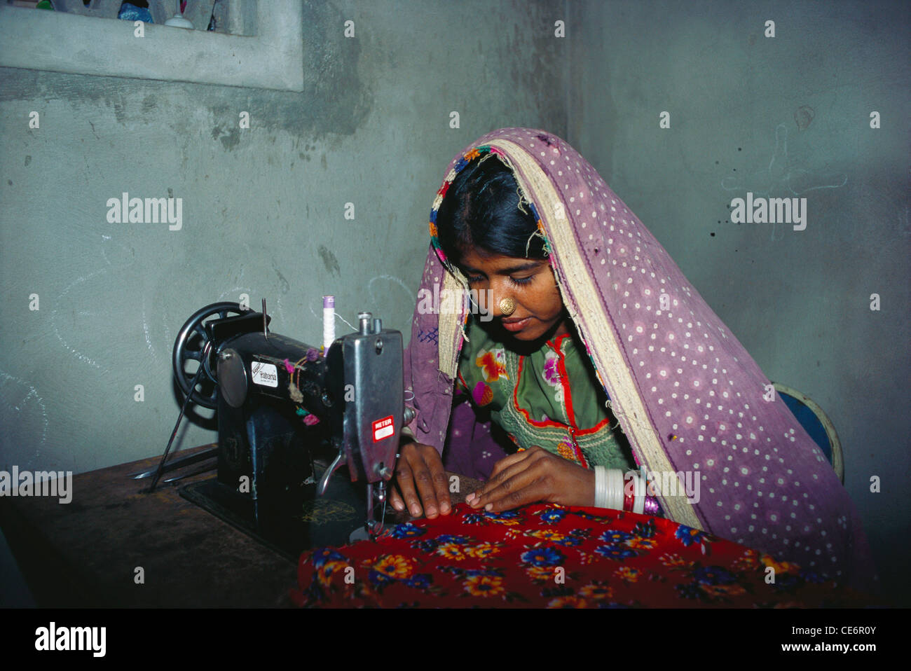 Indian woman working on sewing machine ; india Stock Photo - Alamy