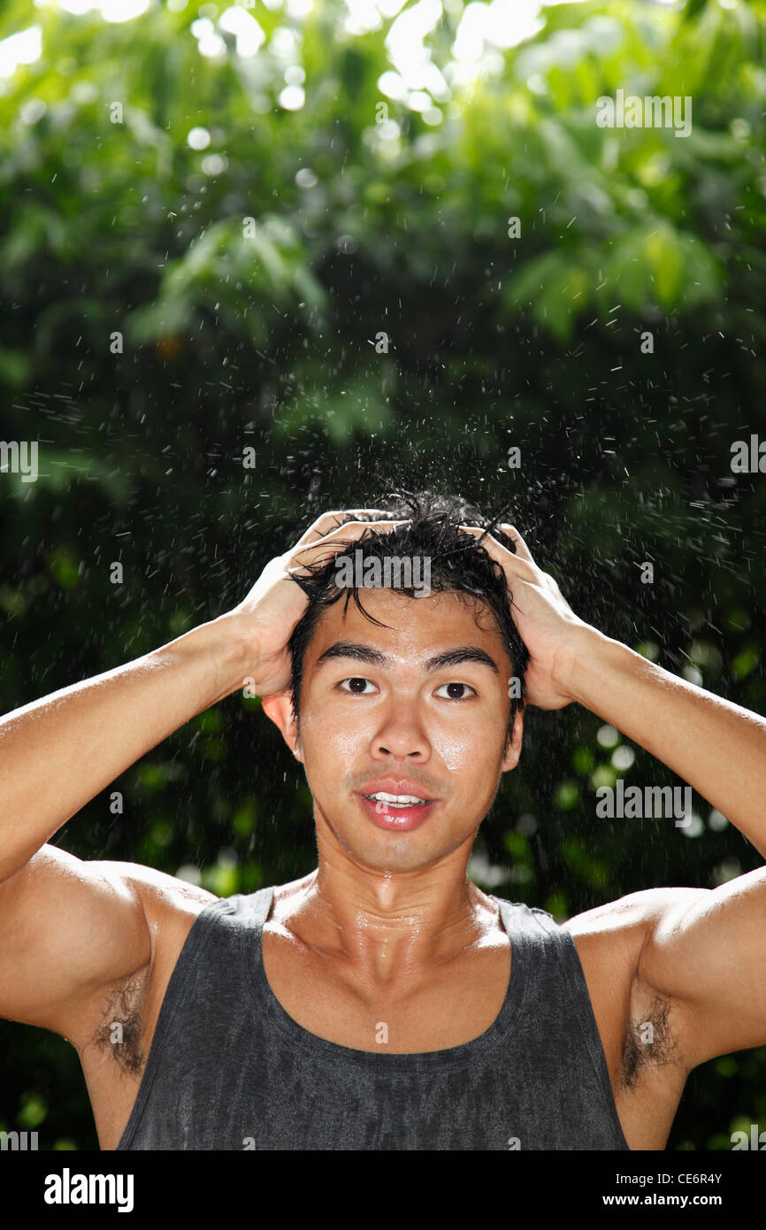 young man covered in water with hands in hair Stock Photo - Alamy