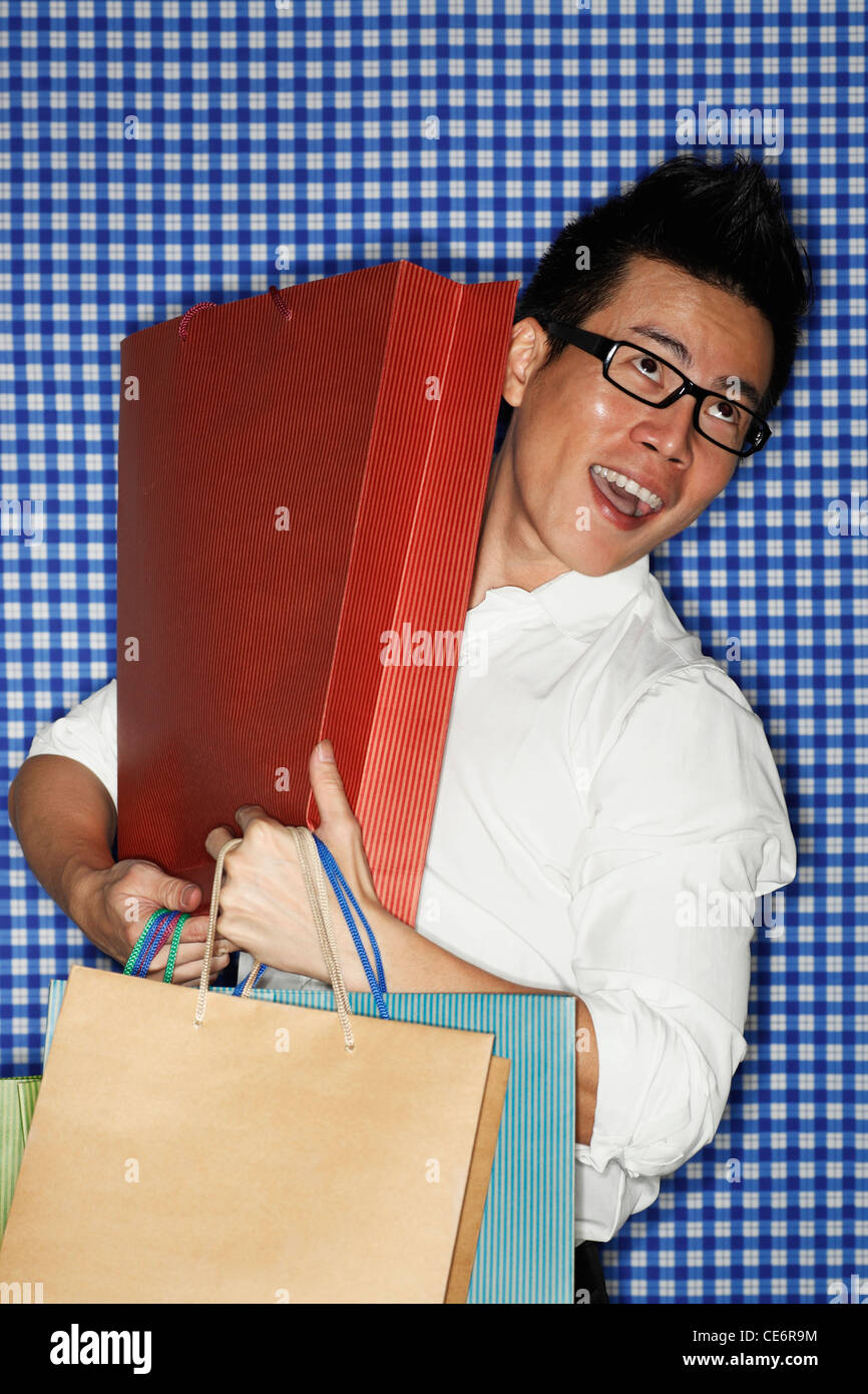 Chinese man holding shopping bags and laughing Stock Photo - Alamy