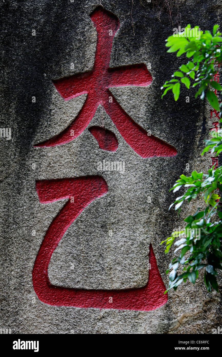 Red Chinese characters carved into a rock Stock Photo - Alamy