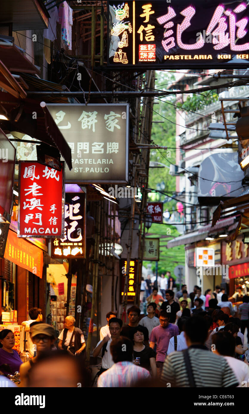 Street signs with busy crowd walking underneath Stock Photo - Alamy