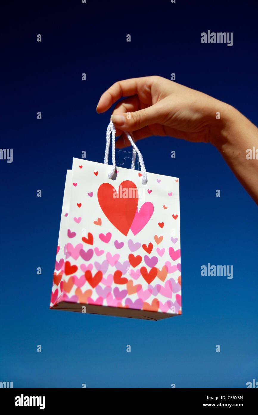 Present in hand on blue sky background Stock Photo - Alamy