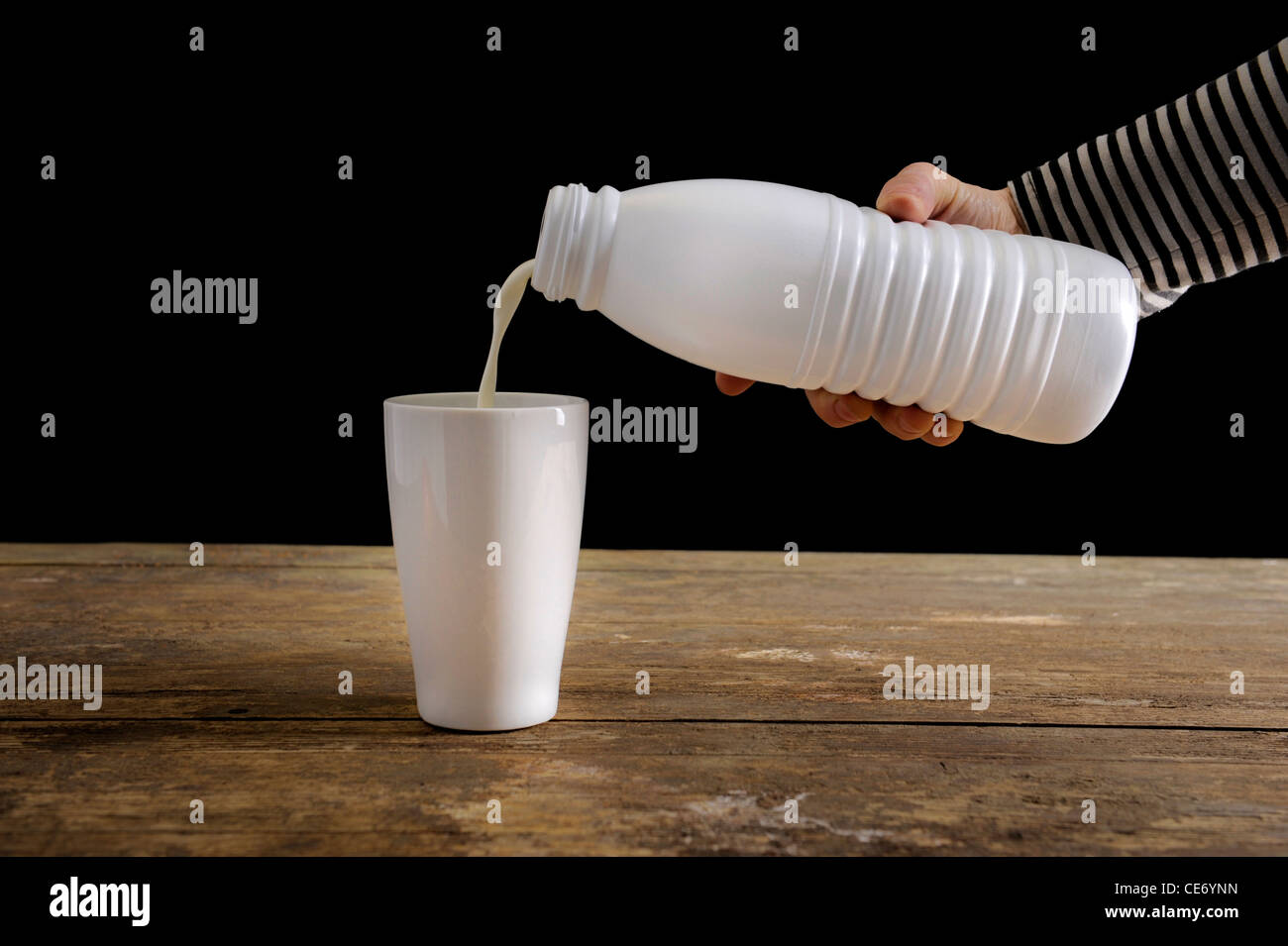 hand pouring milk from a milkbottle in a white cup Stock Photo - Alamy