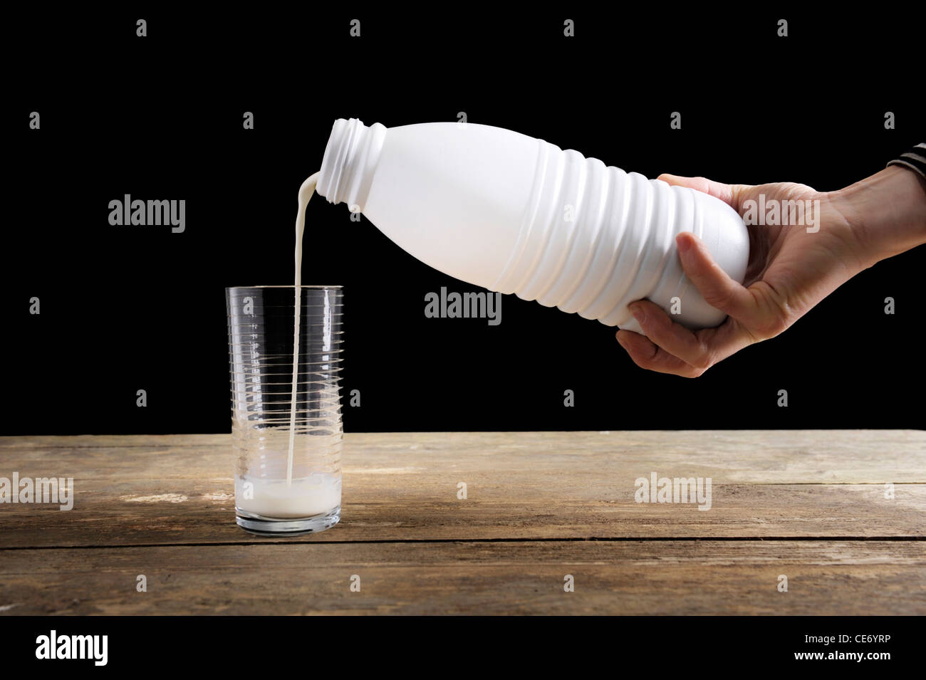 pouring a glass of milk on an old weathered table Stock Photo - Alamy