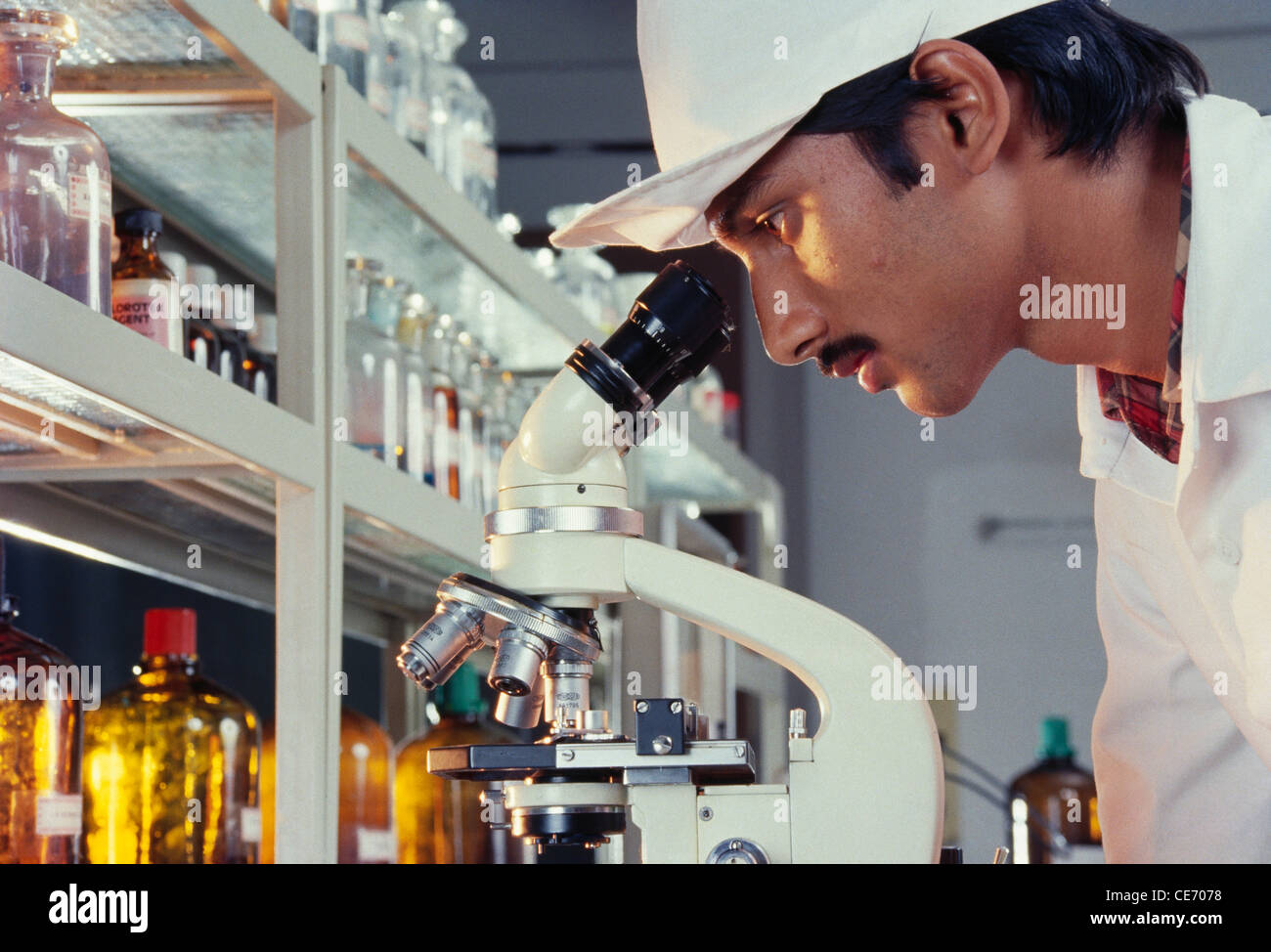 Man looking through microscope in lab Stock Photo - Alamy
