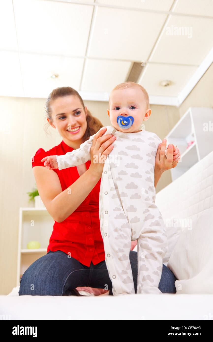 Smiling mother helping baby learn to walk Stock Photo - Alamy