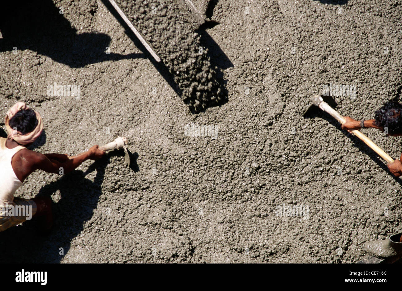Cement sludge ; Indian men working road construction site ; India ...