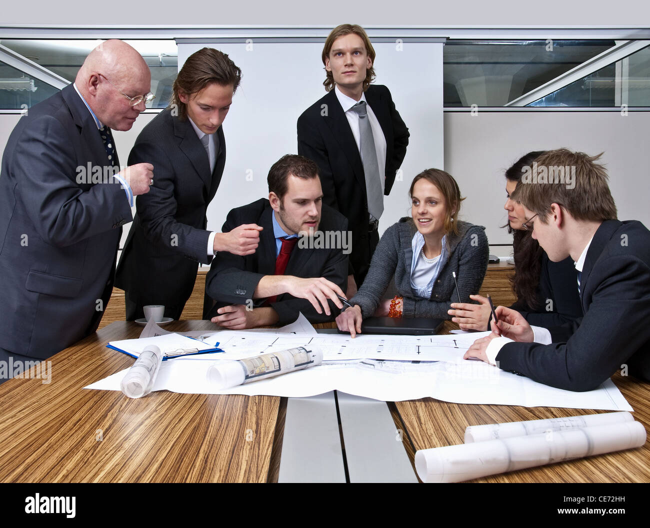 A company manager, and his team, discussing plans in a modern office ...