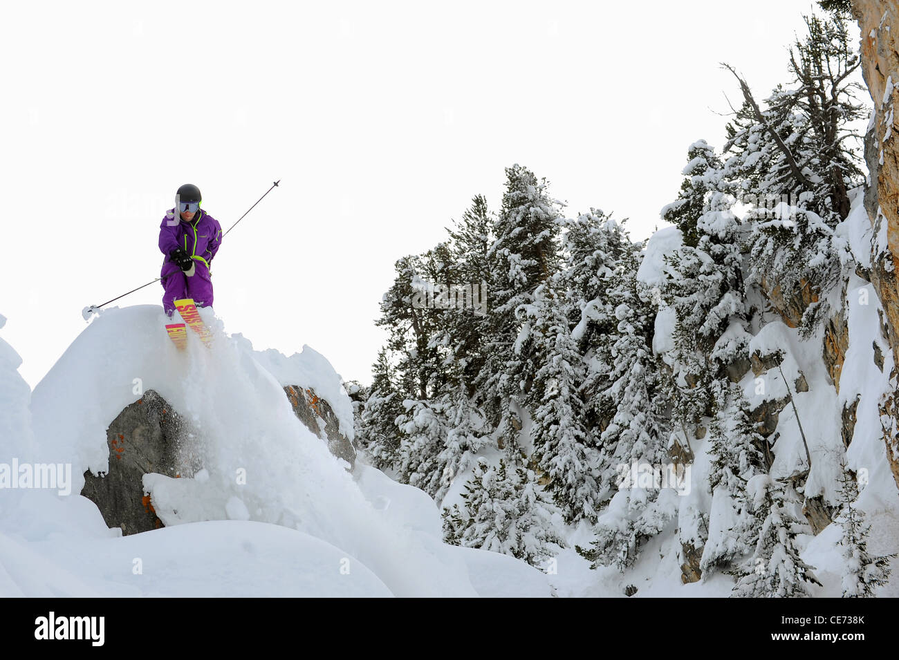 A skier jumps off rocks off piste in the ski resort of Courchevel in ...
