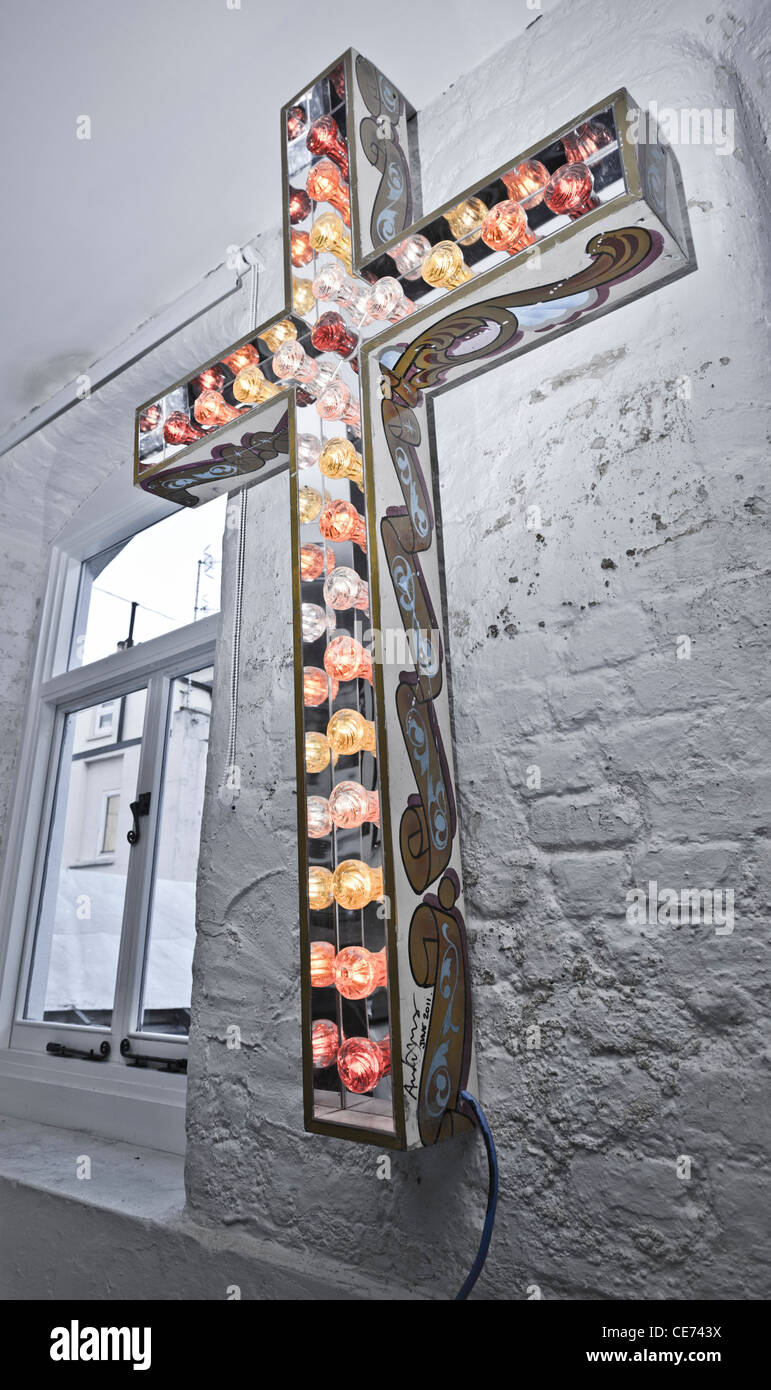 A Fairground crucifix with lights hangs from a wall. Picture by Pete ...