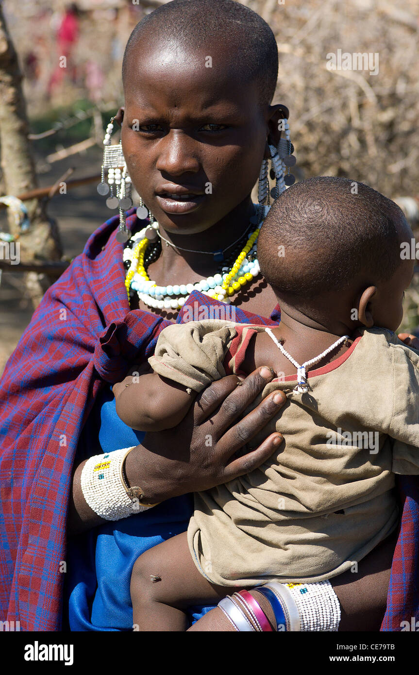 A Masai mother and her baby in Tanzania. She has the usual shaved head ...