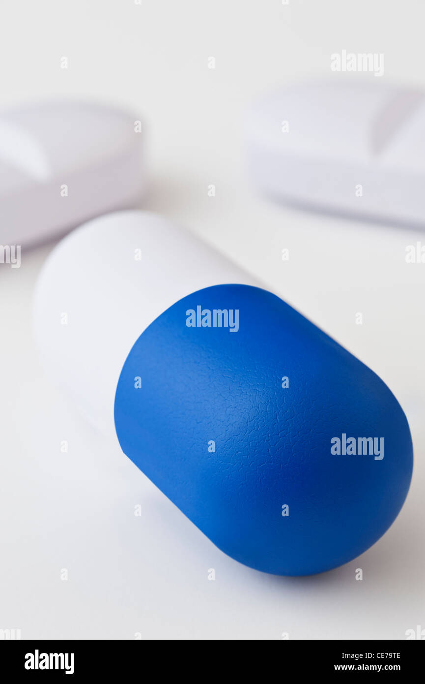 Pills on a white background with a blue and white capsule in the ...