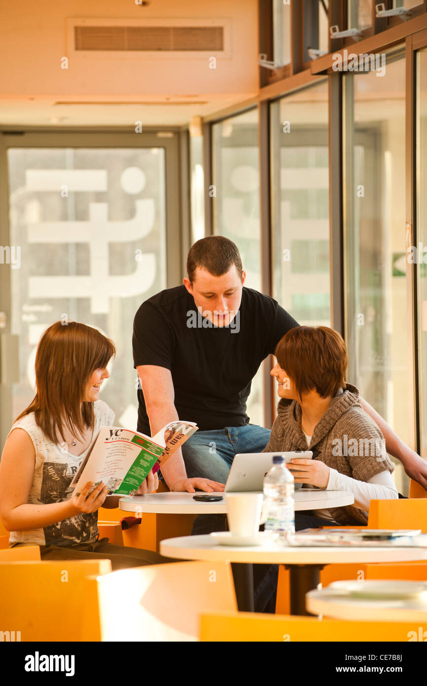 A group of young people - two girls and one boy - talking chatting in a ...