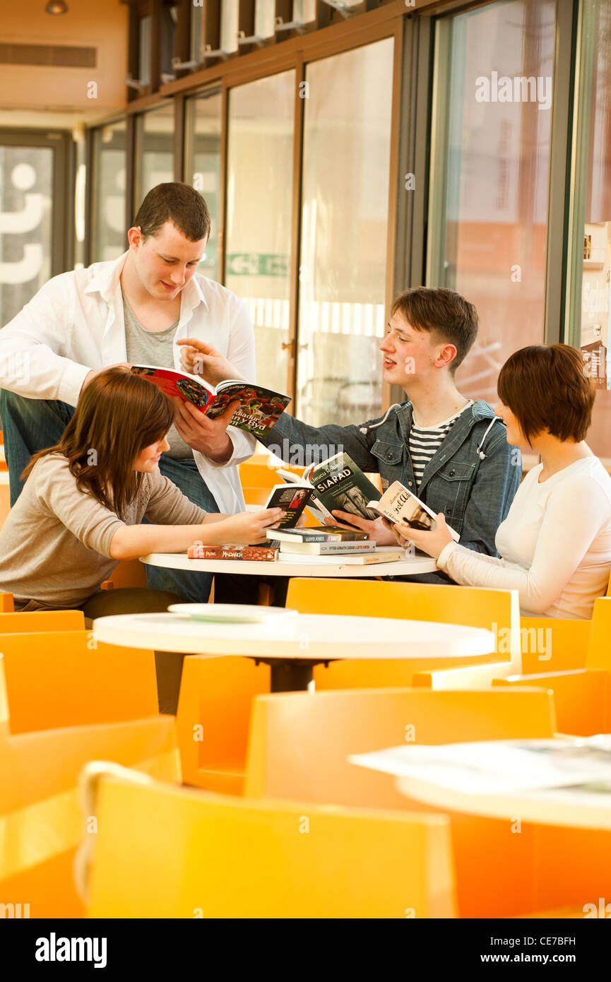 Four young teenagers in a reading group people friends enjoying reading ...