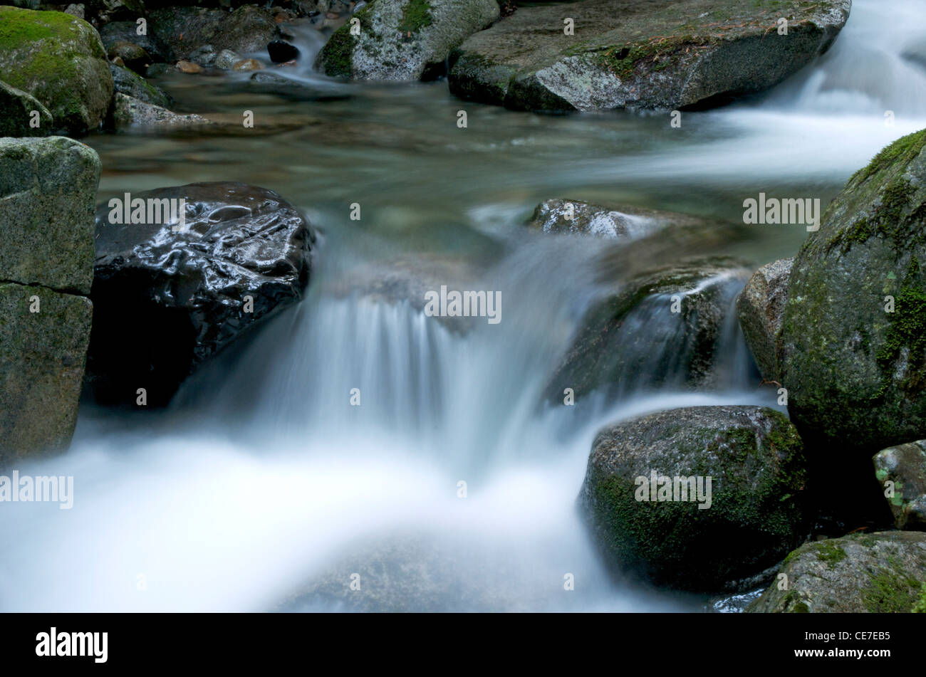Waterfalls flow over river rocks, fresh mountain stream water shot on ...