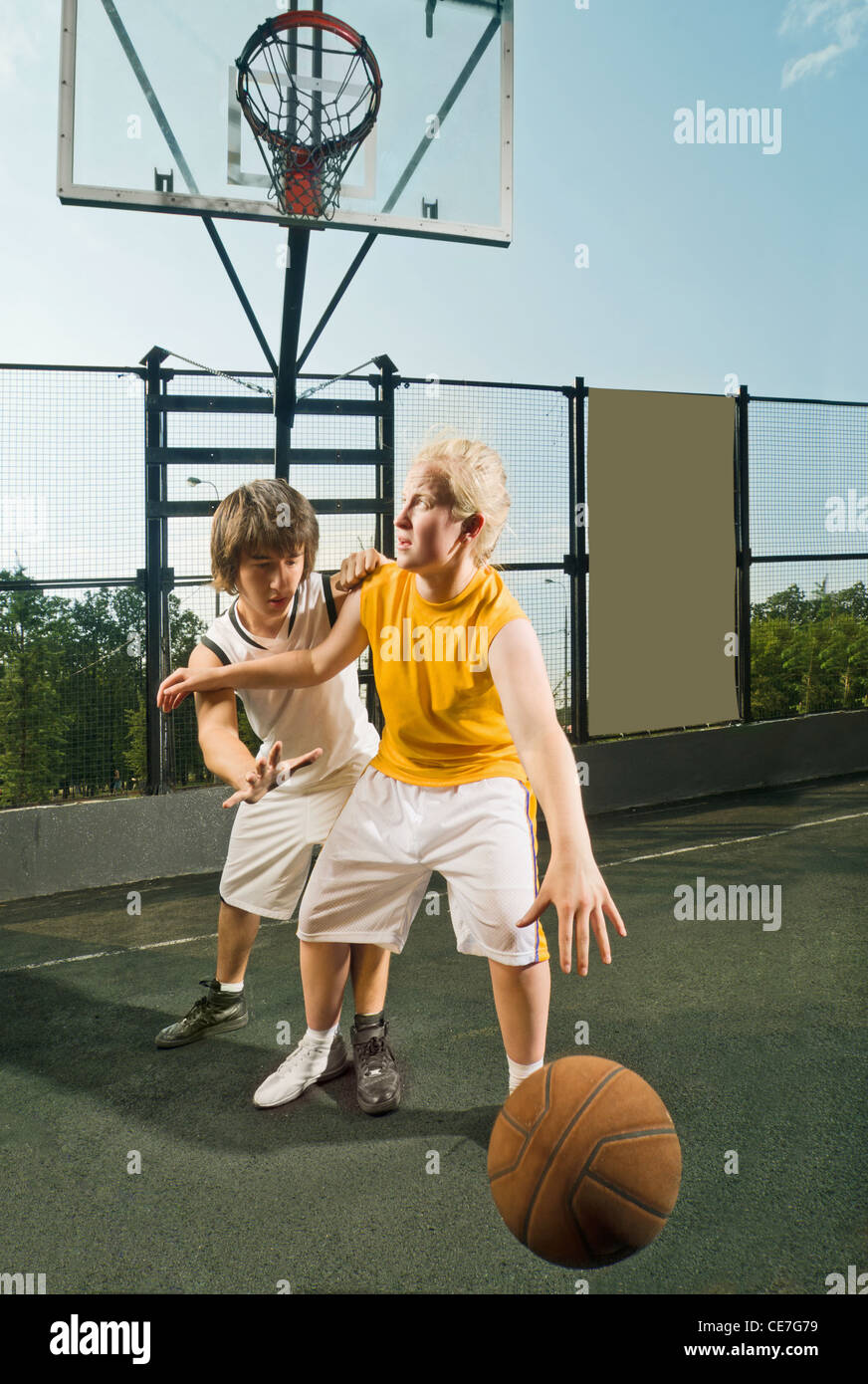 Two teenagers playing basketball at the street playground Stock Photo ...