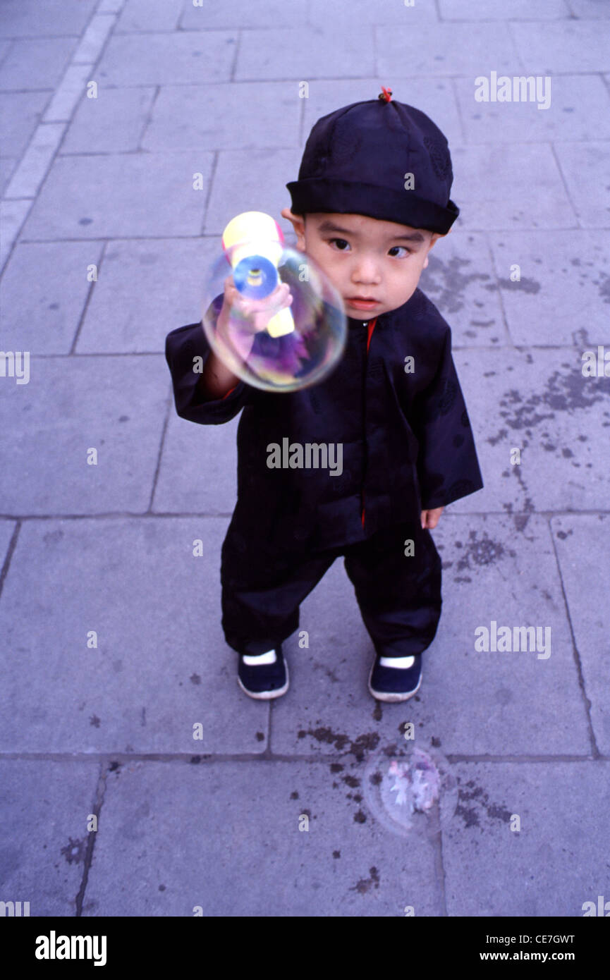 A young boy playing with bubble soap pistol in Beijing China Stock ...