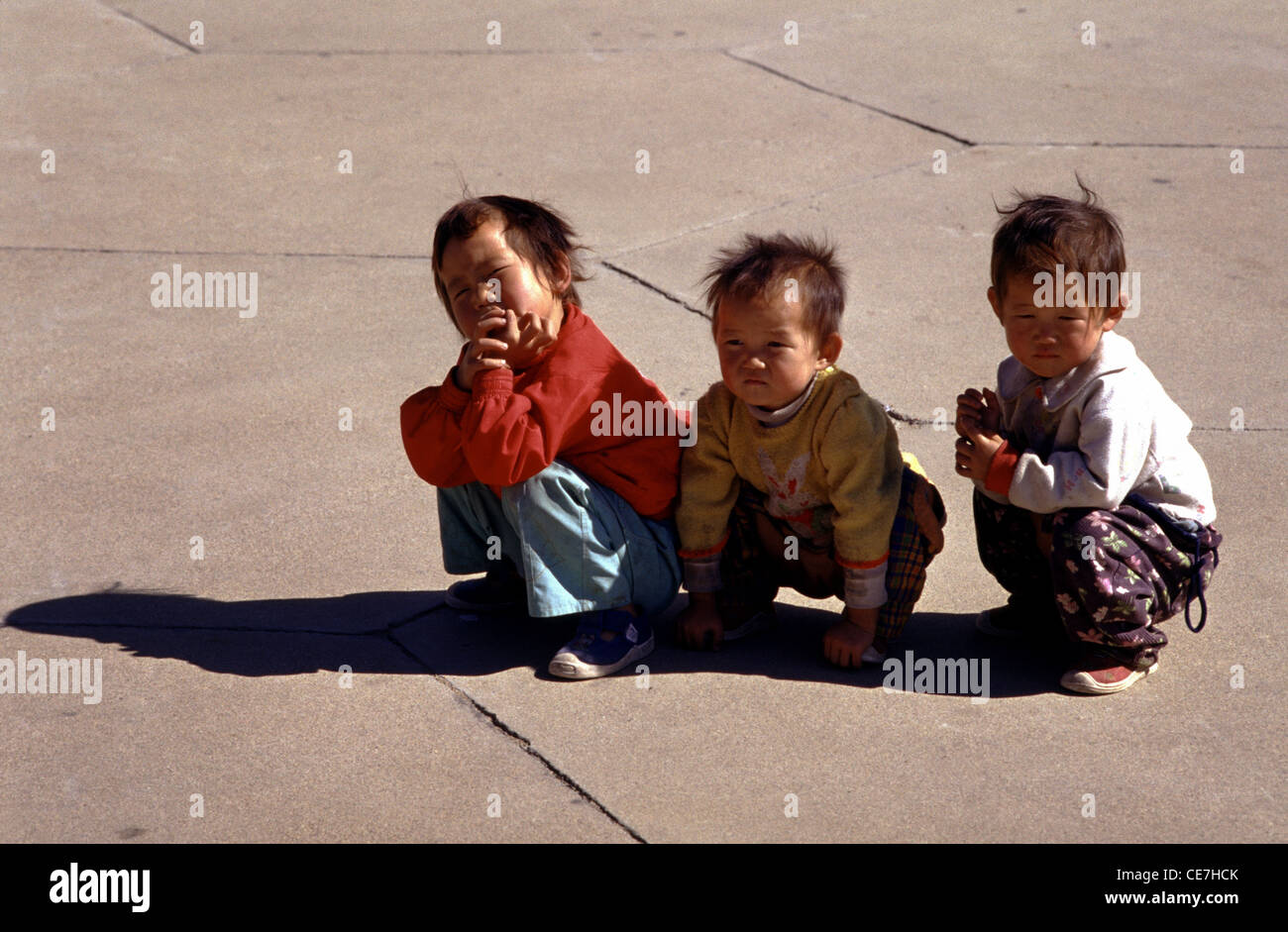 Three Chinese toddlers sitting in a courtyard China Stock Photo - Alamy