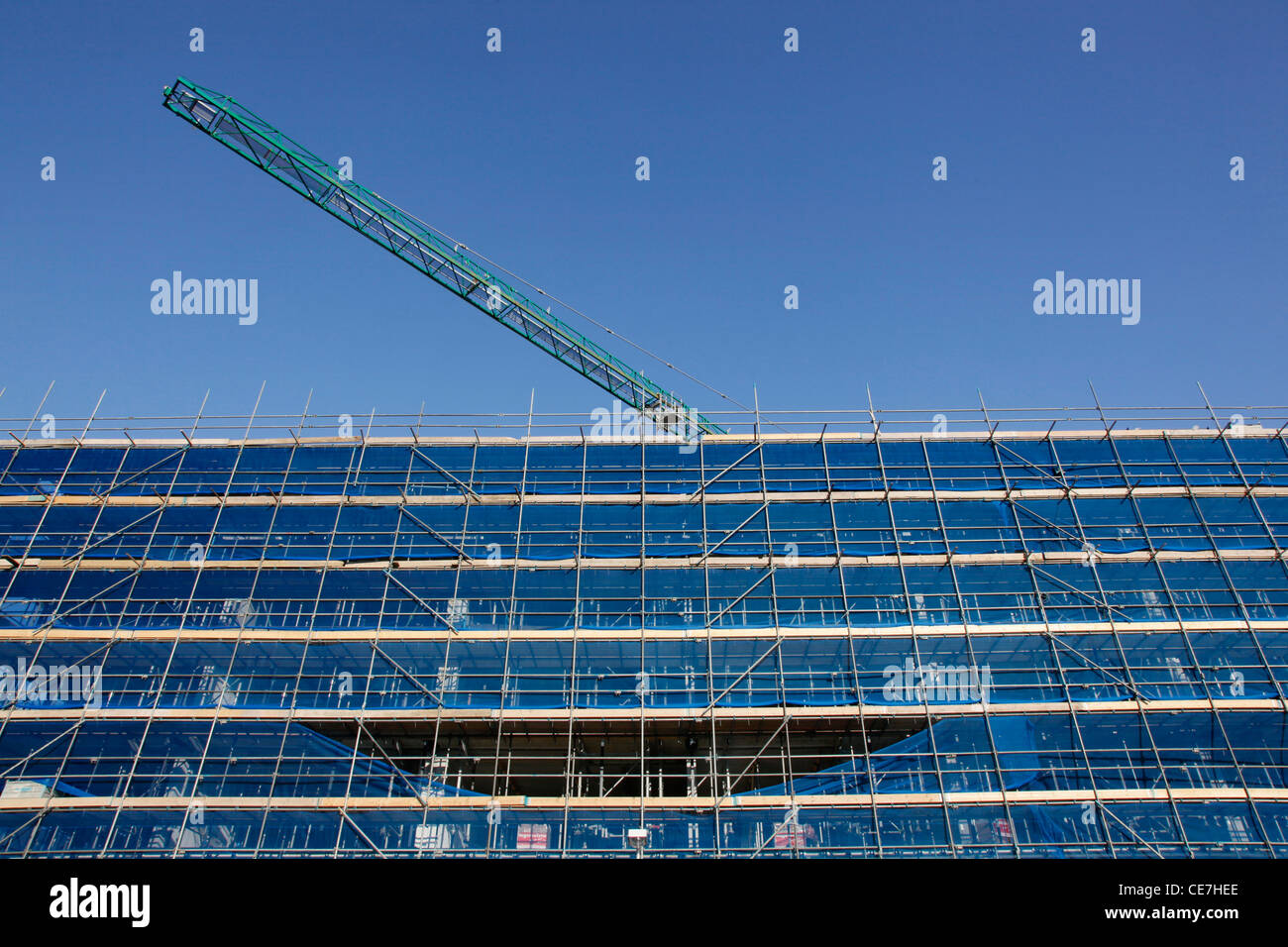 building under construction with blue scaffolding and blue sky Stock ...