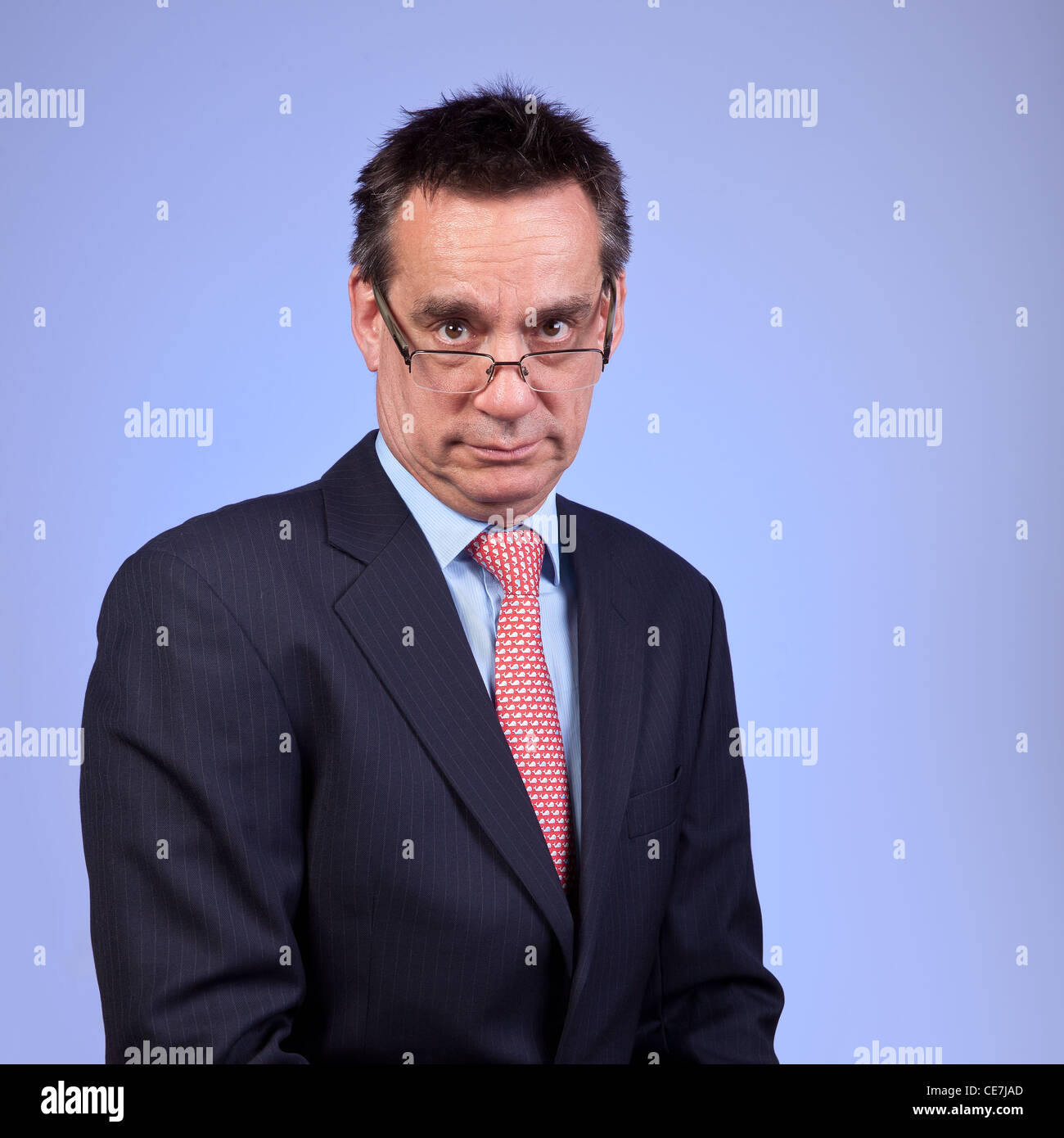 Grumpy Frowning Middle Age Business Man in Suit Looking over Glasses on ... Grumpy Frowning Middle Age Business Man in Suit Looking over Glasses on ...