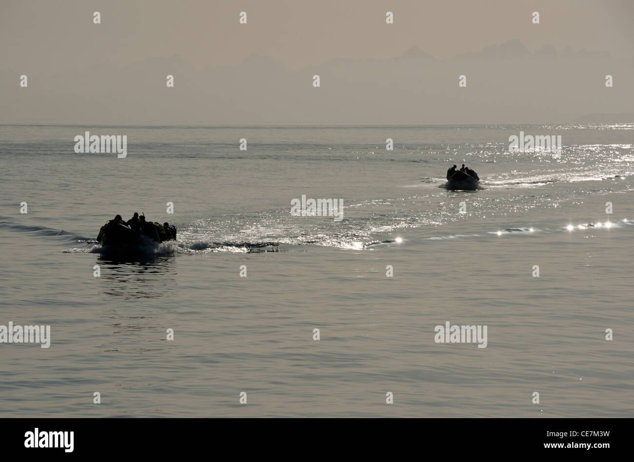 Scuba divers traveling to a dive site in inflatable boats Stock Photo ...