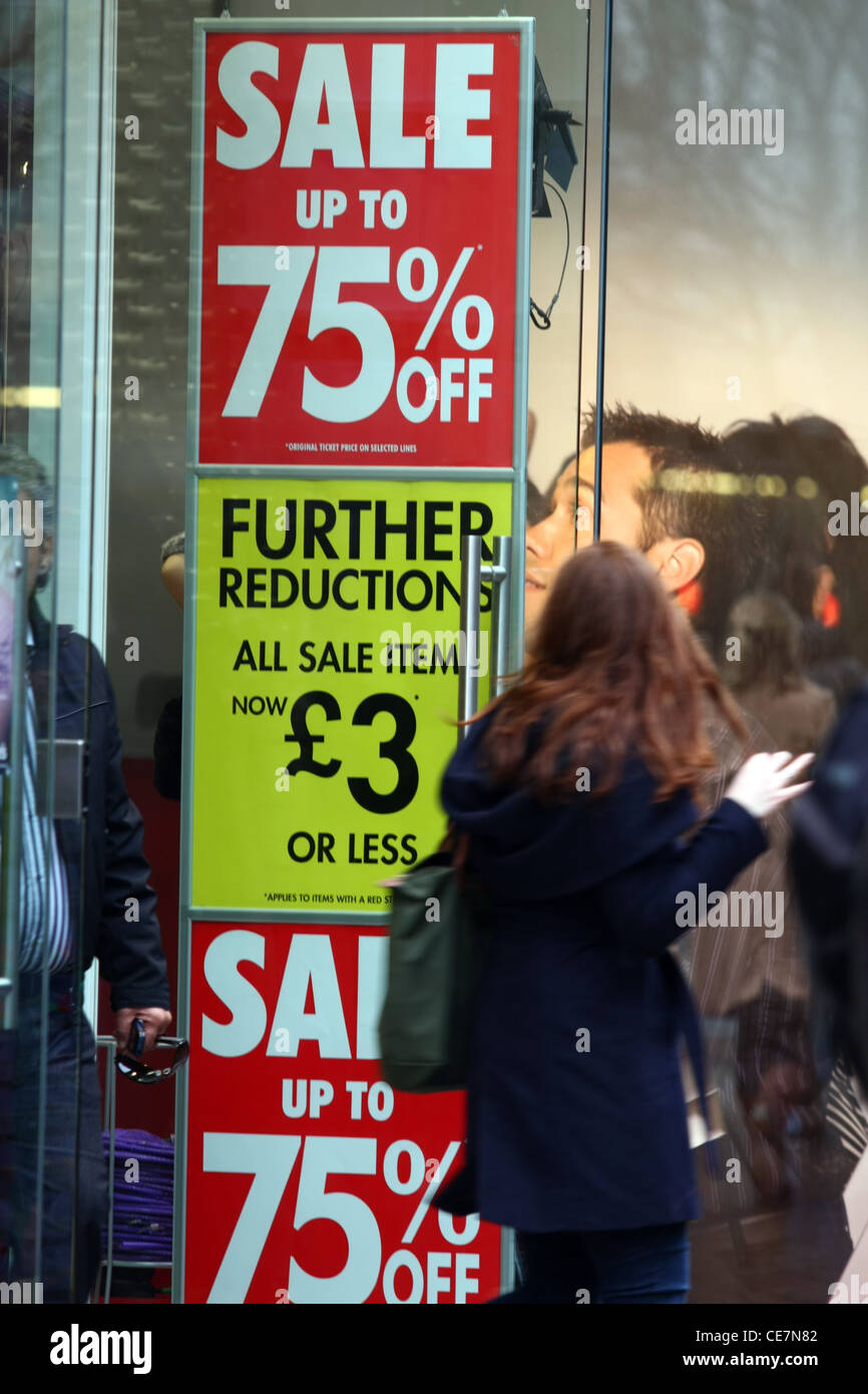 sale sign in a shop window with a girl looking at the signs and ...