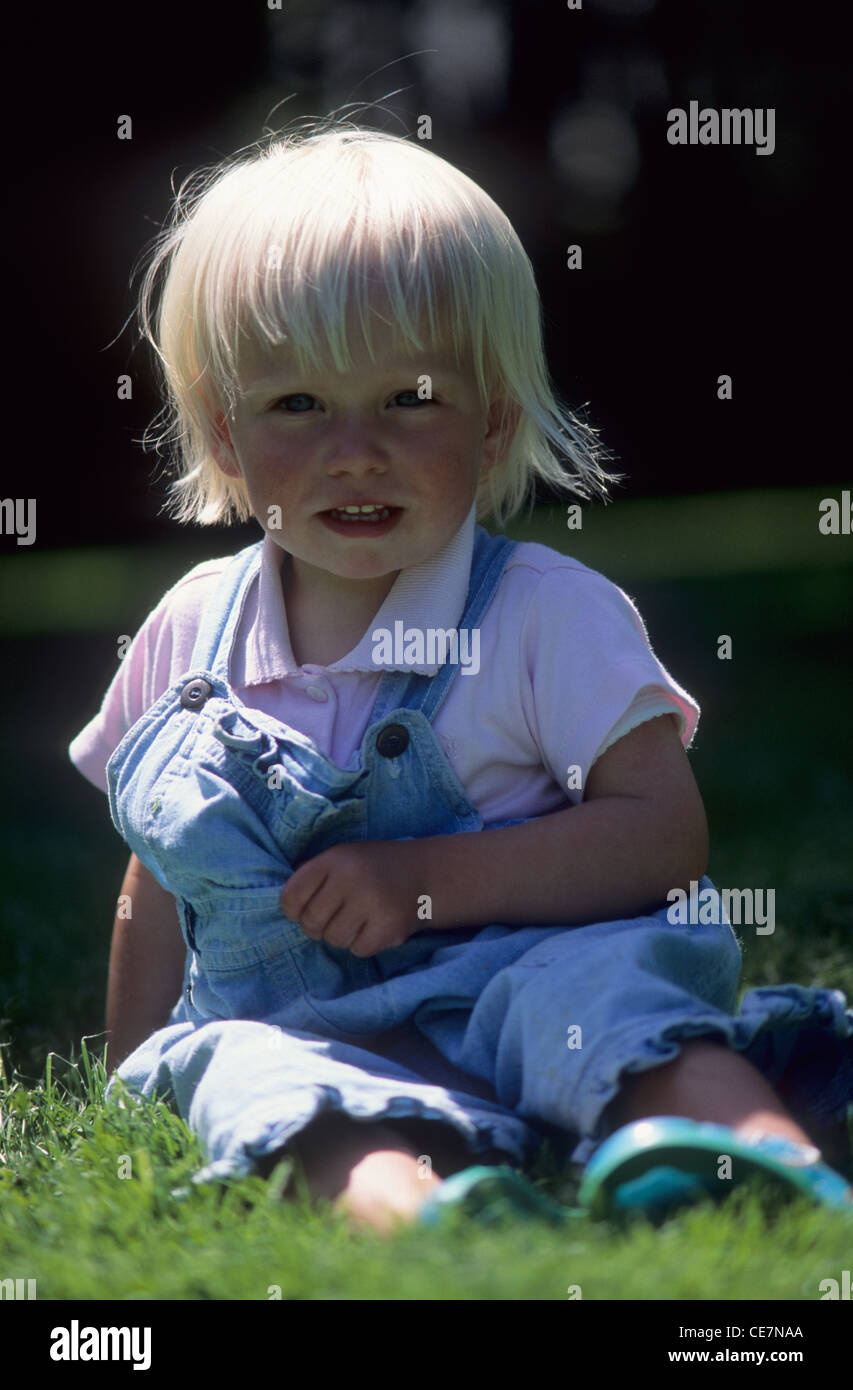 Small child sitting in a park Stock Photo - Alamy
