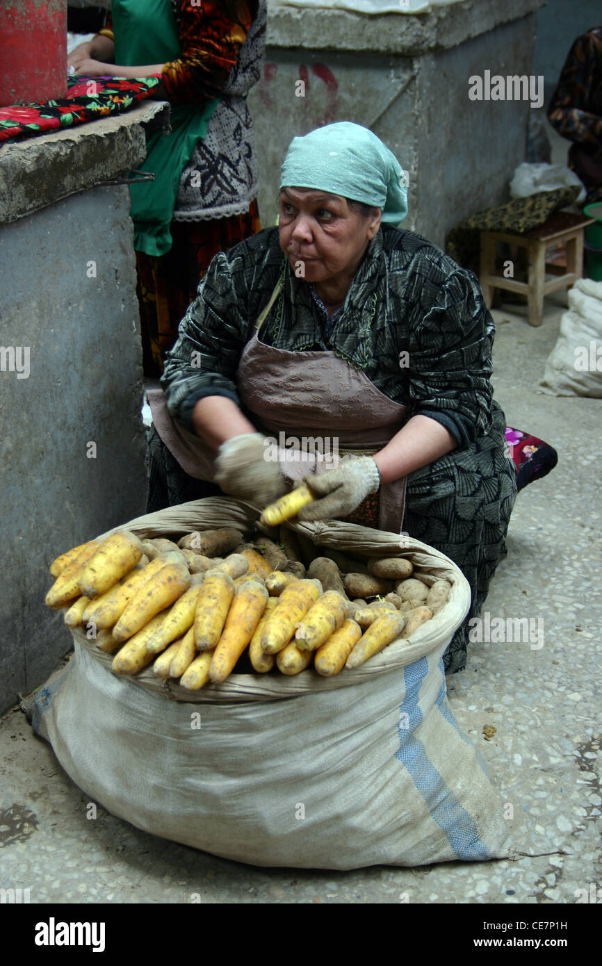 Traditional lady preparing vegetables in a market in Samarkand in ...